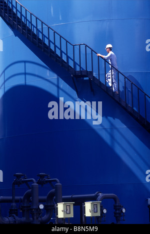Oil industry worker climbing stairs on storage tank Stock Photo - Alamy