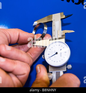 Vernier caliper measuring a mechanical part placed on top of a ...