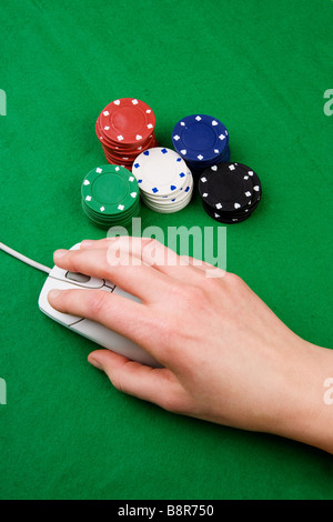 An online gambling concept - computer mouse, hand and casino chips ...