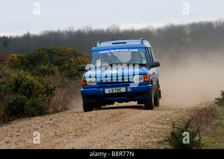 Land Rover Discovery rally car splashes through puddle driving on mud ...