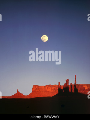 Moon over the Totem Pole and the Yei Bi Chei in silhouette before dawn ...