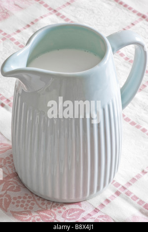Blue and white jug filled with milk beside three eggs Stock Photo - Alamy