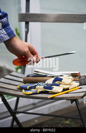 Hand with glove holding hammer at outdoor Stock Photo - Alamy