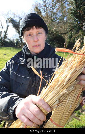 Kate Glover a master thatcher working on a roof near Newbury Stock ...
