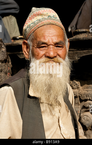 Man in traditional Nepali clothes sitting under the stone arches of ...