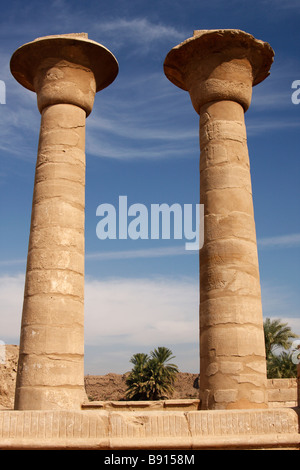 Large stone papyrus column with carved hieroglyphics next to old wooden ...