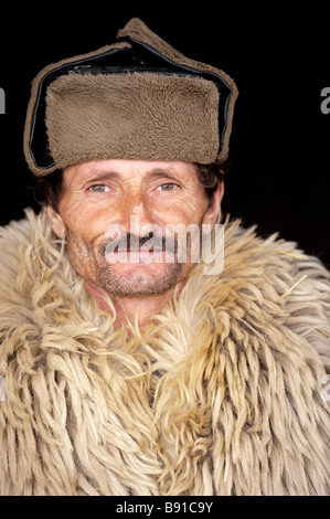 Romanian shepherds in traditional clothing including a big heavy sheeps ...