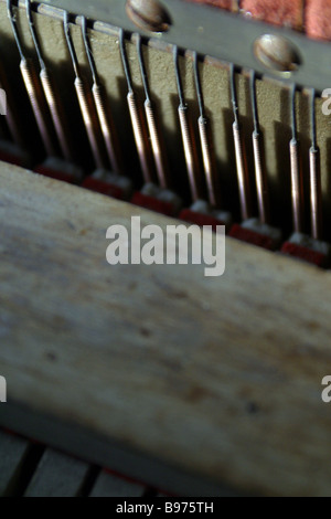 The inside workings of an upright piano showing the strings and hammers ...