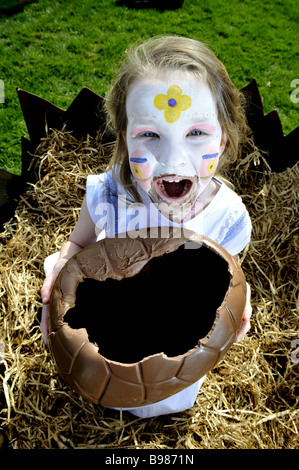 Easter blond girl holding big yellow egg and bunny in background Stock ...