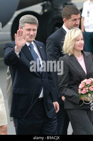 Prime Minister Stephen Harper and his wife wave to the media while ...