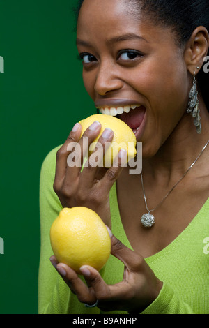 Close up of woman biting lemon Stock Photo - Alamy