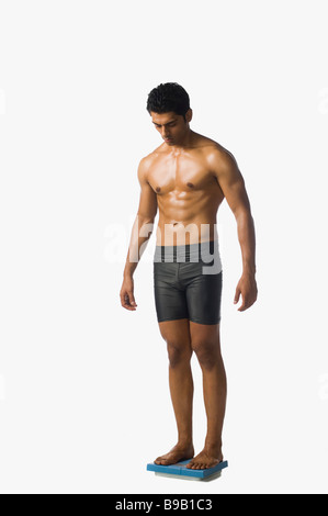 Man measuring his weight on a weighing scale Stock Photo: 22984872 - Alamy