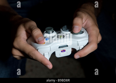 A young teen holding an Xbox One controller while playing Xbox games ...
