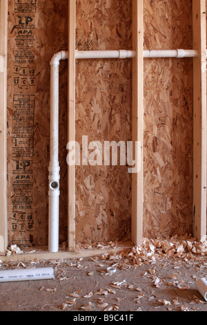 Rough plumbing pipes and drain installed in a wall at residential ...