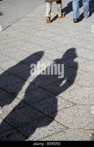 Silhouettes and shadows of two women walking down the street. Concept ...