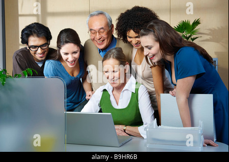 Group of business people looking at laptop computer screen, working ...