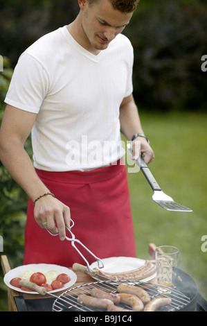 Barbeque time. Man barbecuing meat on the grill while standing on the ...