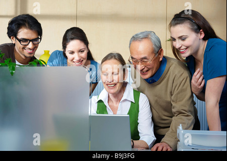 group of people looking at laptop Stock Photo - Alamy