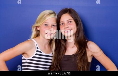 Girl friends two 11 year old girls walking together on a country path ...