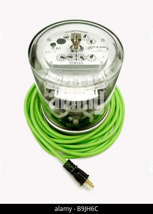 Electric power meter wrapped by a green electrical extension cord and ...