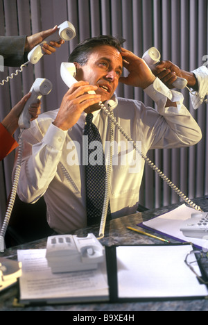 UNHAPPY OFFICE WORKER ANSWERING MANY TELEPHONES AT ONCE Stock Photo - Alamy