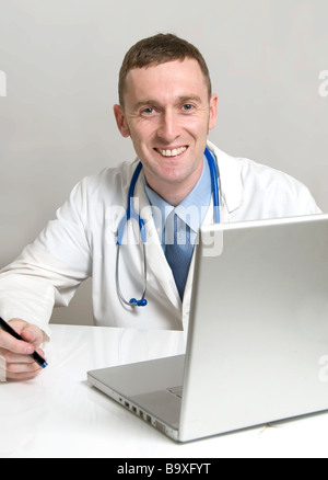 Young Asian woman sitting at desk writing notes on tablet smiling ...