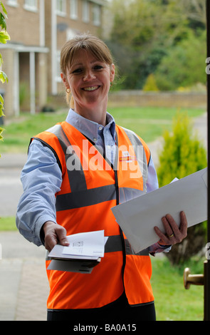 Royal Mail postwoman delivering mail to a customer Stock Photo - Alamy