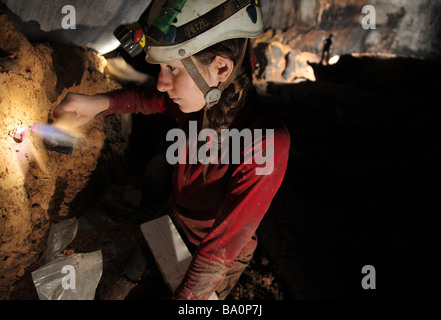 Young female PhD student takes core sediment samples from a mud bank in ...