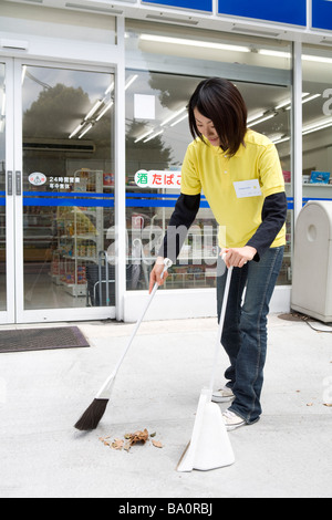 Convenience store clerk cleaning up store Stock Photo - Alamy