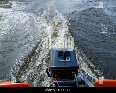 outboard motor engine on speedboat, in water showing wash which causes ...