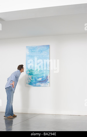Man contemplating paintings in gallery Stock Photo - Alamy