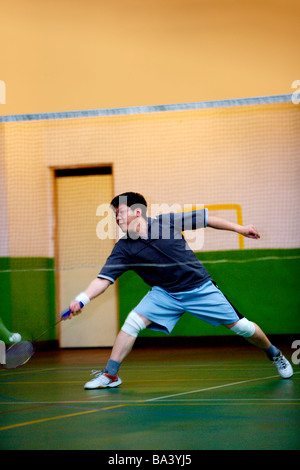 Man hitting shuttlecock with badminton racket Stock Photo - Alamy