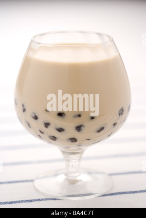 A glass cup of pearl milk tea (also called bubble tea) and a plate of ...