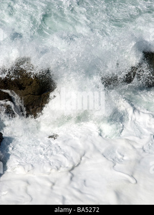 The waves crashing into the rocks making foam on a windy day Stock ...