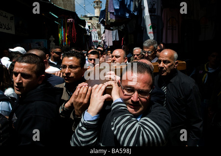 Christian Arab worshipers carry a large wooden cross as they take part ...