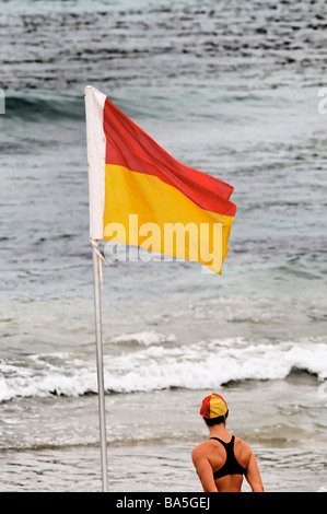 Australian Surf Life Saver at waters edge wearing a DHL Beach Patrol ...