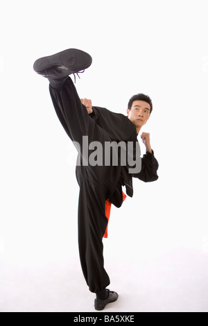 Young man performing side kick Stock Photo - Alamy