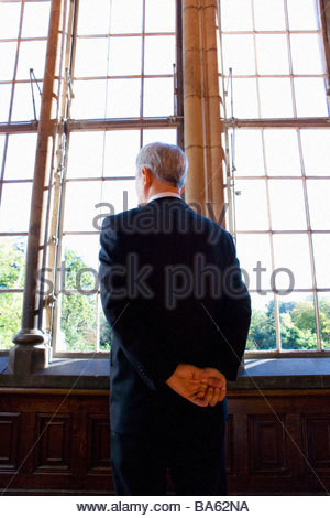 Man standing behind window, hands pressed against glass, looking Stock ...