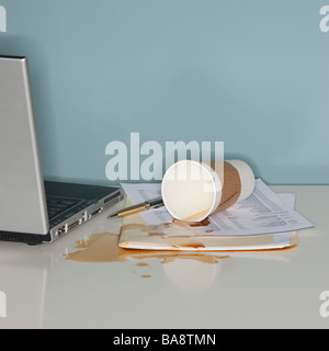 Cup of coffee spilled on office desk concept of careless clumsy or ...