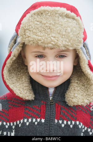 A happy boy in a winter hat and snow-covered mittens. A child in winter with ice sleds Stock ...