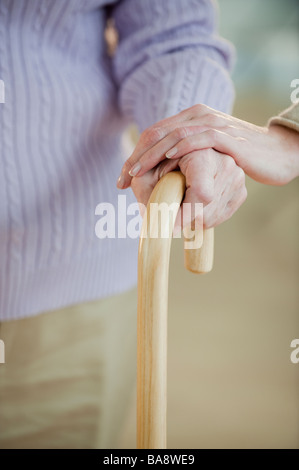 Close up of a senior woman holding two small wild mushrooms in her ...