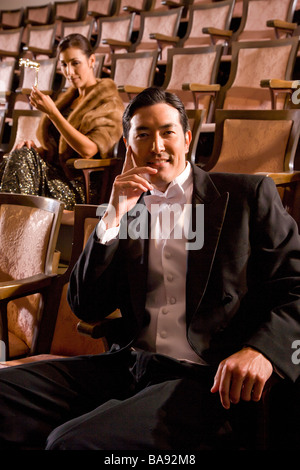 Hispanic male in elegant coat holding bag while standing on city street ...
