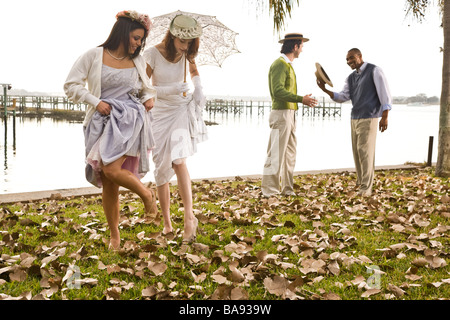 Portrait of 1920s socialite men relaxing at garden party on water's ...