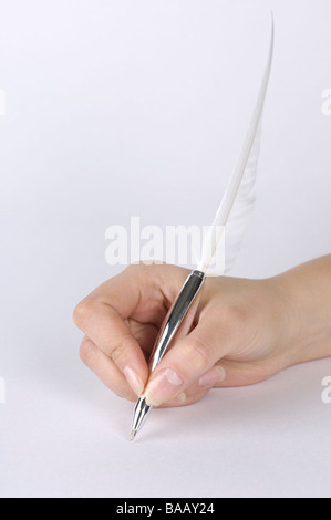 Hand holding quill-pen Stock Photo - Alamy