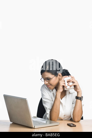 Woman concentrating on her phone while telecommuting from a local ...