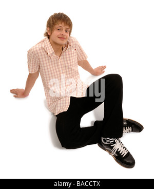 Relaxed teen boy sitting on chair in white studio space Stock Photo - Alamy