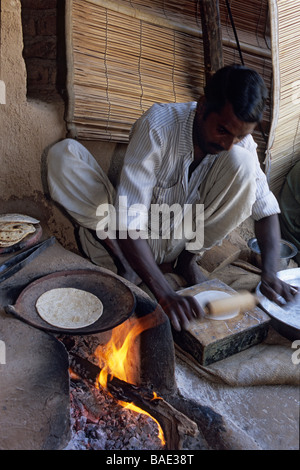 India, Rajasthan State, Udaipur, Apani Dhani restaurant, man peeling ...