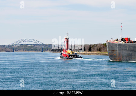 Red tugboat pulling barge through canal Stock Photo - Alamy