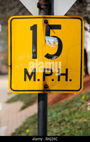 Weathered 15 MPH Speed Limit Sign with Graffiti and Green Foliage ...