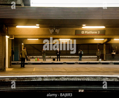 Passengers wait for a train at a platform in the central train station ...